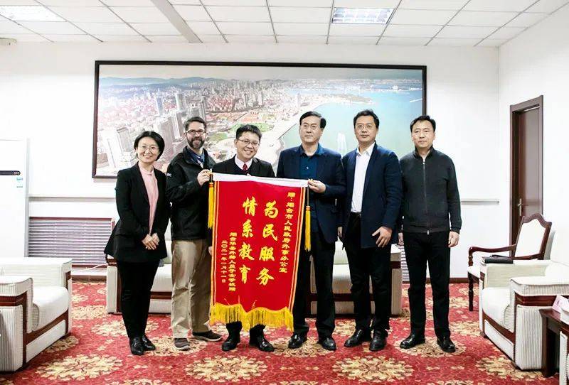 华圣外籍人员子女学校到市外办赠送锦旗_烟台